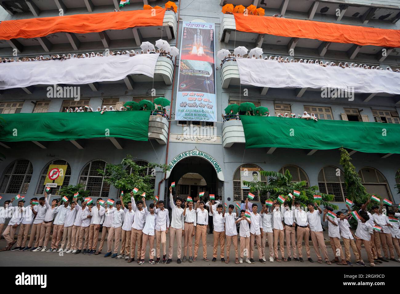 Students carry umbrellas in the colors of the Indian national flag in ...
