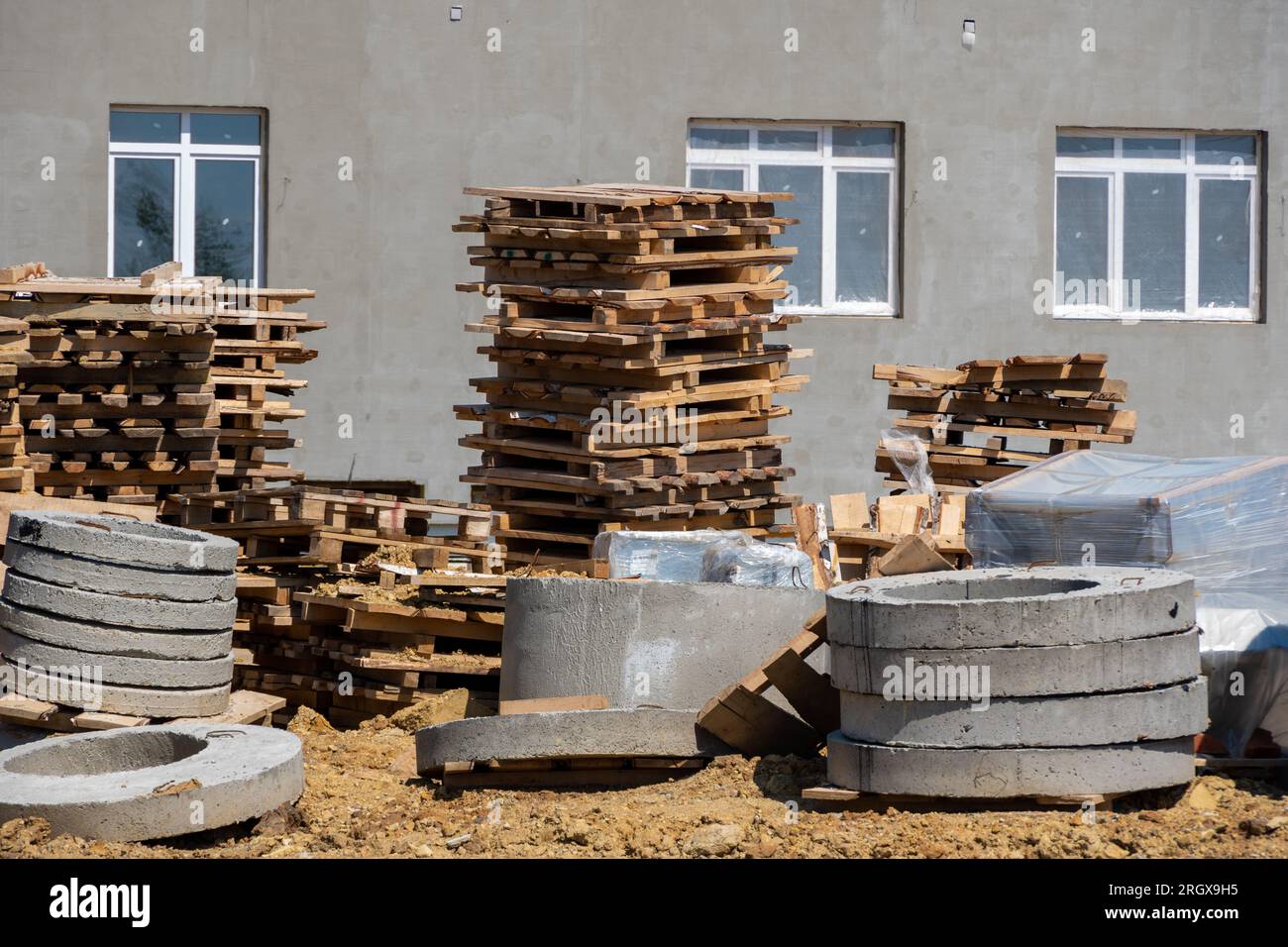 Concrete blocks for construction on wooden pallets. A construction site with a building frame in ...