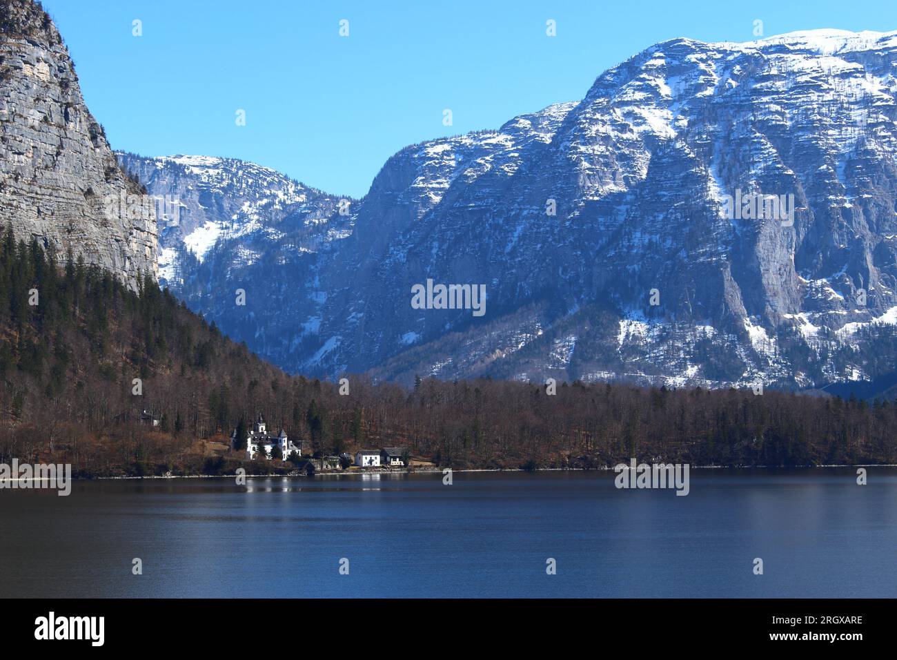Alpine mountain lake on a cloudless day in winter. Lack of snowfall in ...