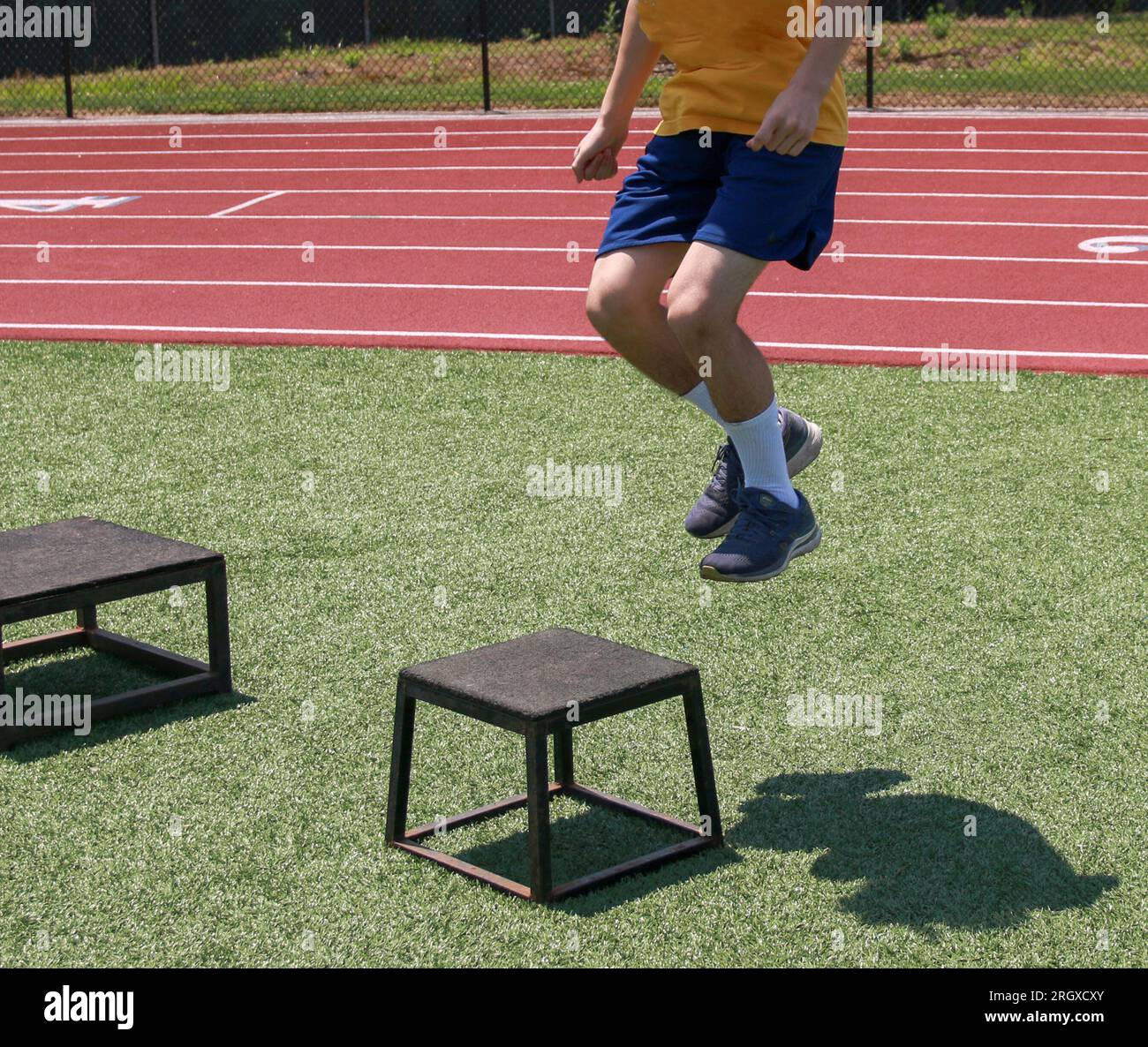 Front view of one teenage boy in the air jumping onto a small black ...