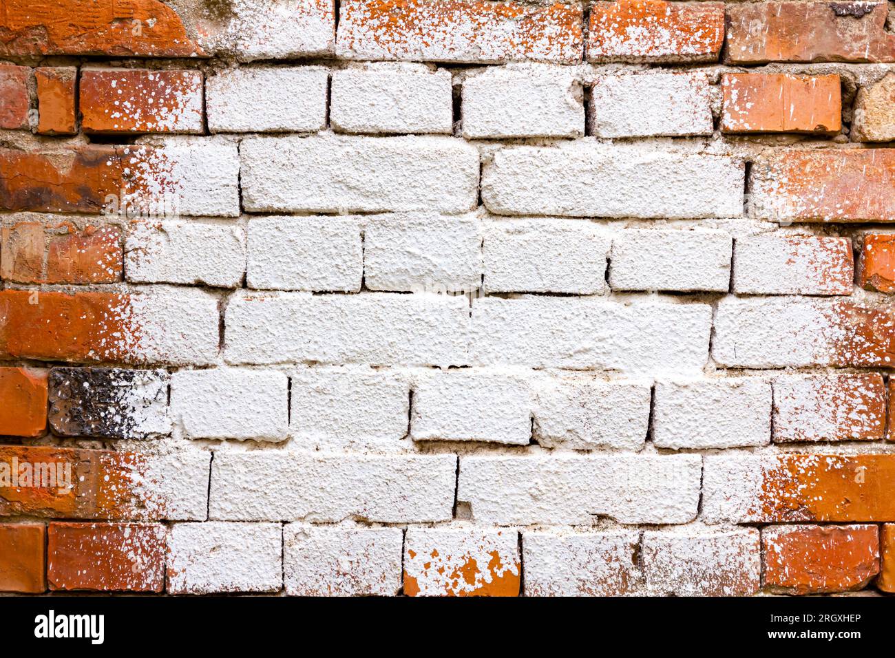 Old dilapidated wall of damaged red bricks stained with a whitewash ...