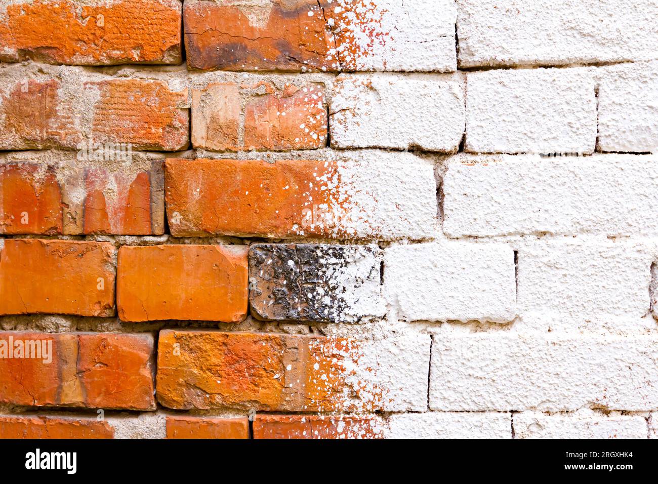 Old dilapidated wall of damaged red bricks stained with a whitewash ...