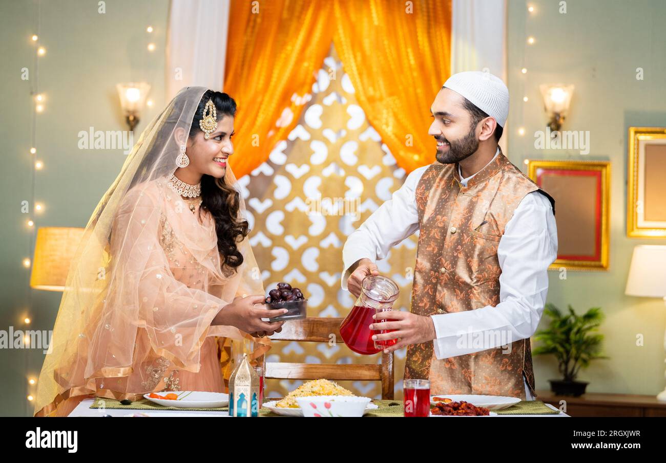 Happy indian couple arranging ramadan feast or food preparing by ...