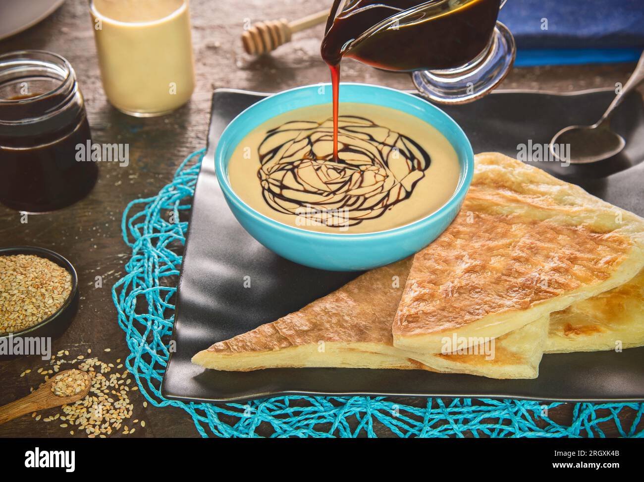 Drizzling a nice pattern of molasses over tahini sesame sauce. Middle ...