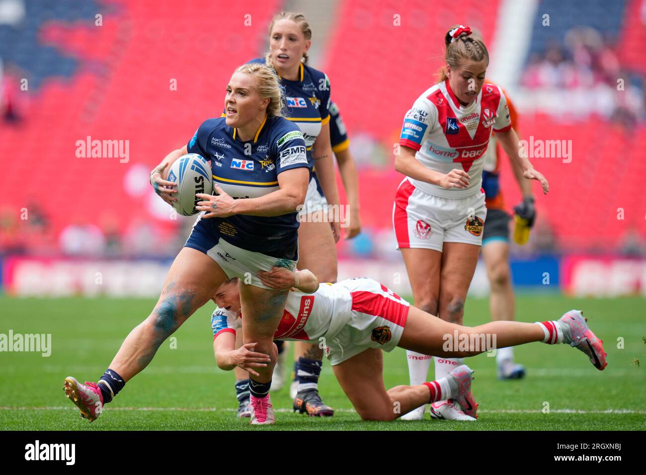 Amy Hardcastle #11 of Leeds Rhinos drives through a tackle during the ...