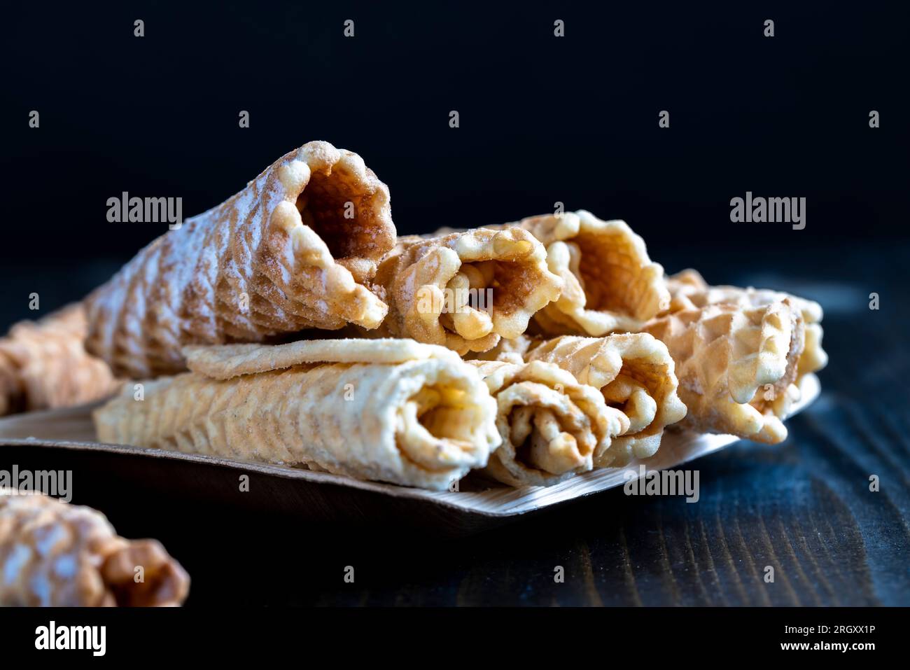 thin crispy waffles lie on a black table, sweet food for desserts Stock ...