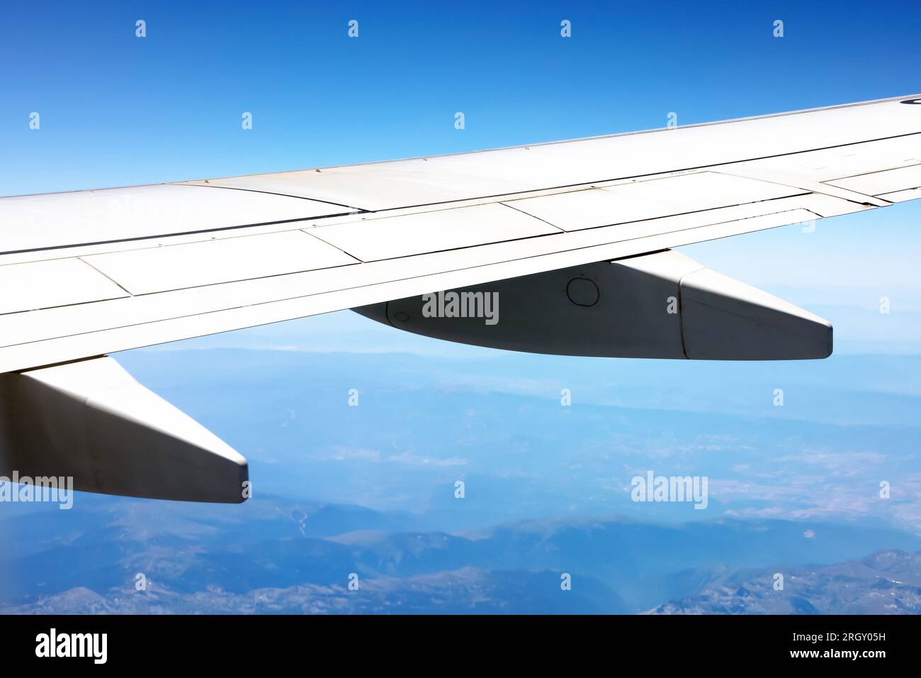 An airplane in the air. Airplane wing with view of mountains underneath ...