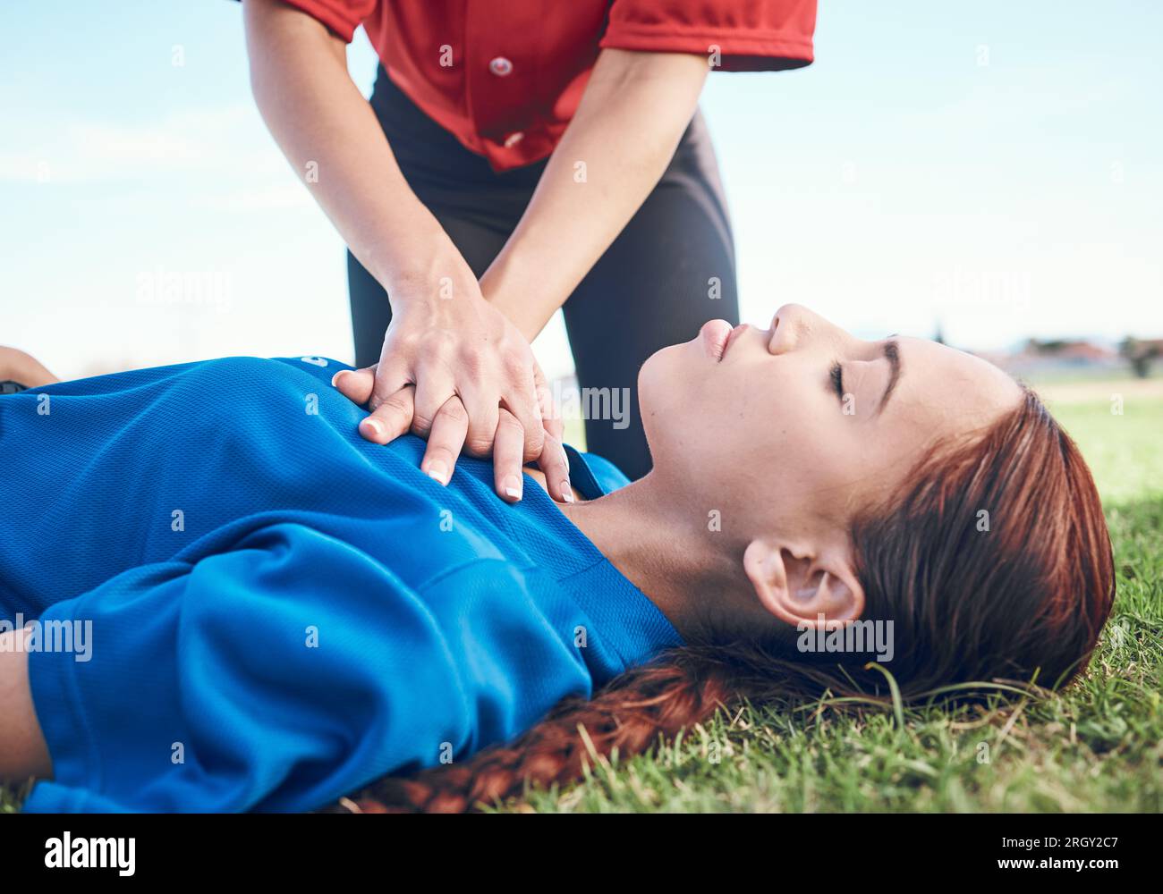 Cpr, outdoor and hands on chest, women and help on a field ...