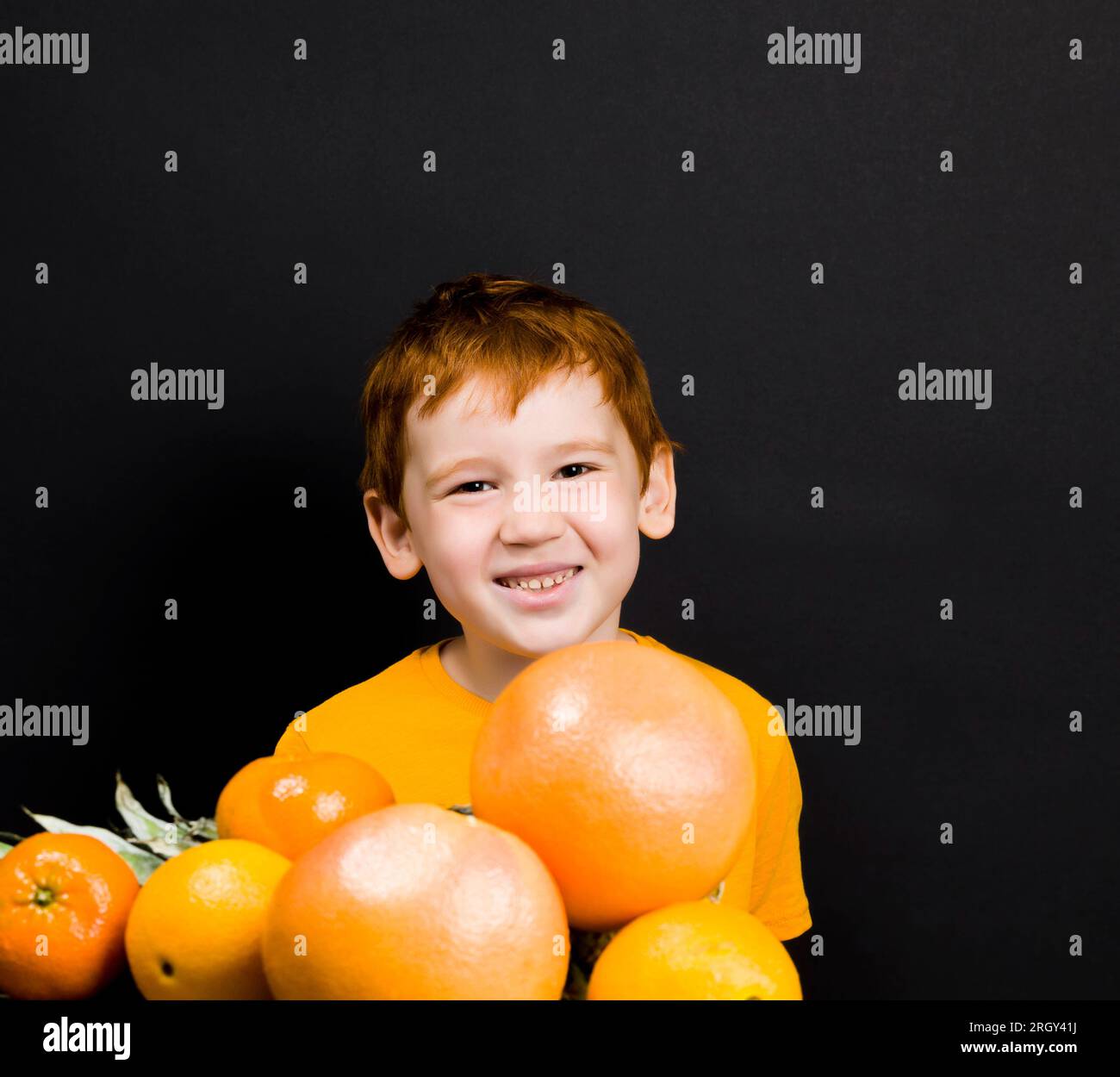 a beautiful red-haired boy with citrus fruits from which you can make ...