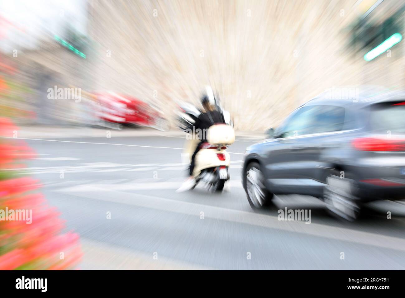12 August 2023, Bavaria, Würzburg: A young woman sits on a scooter ...