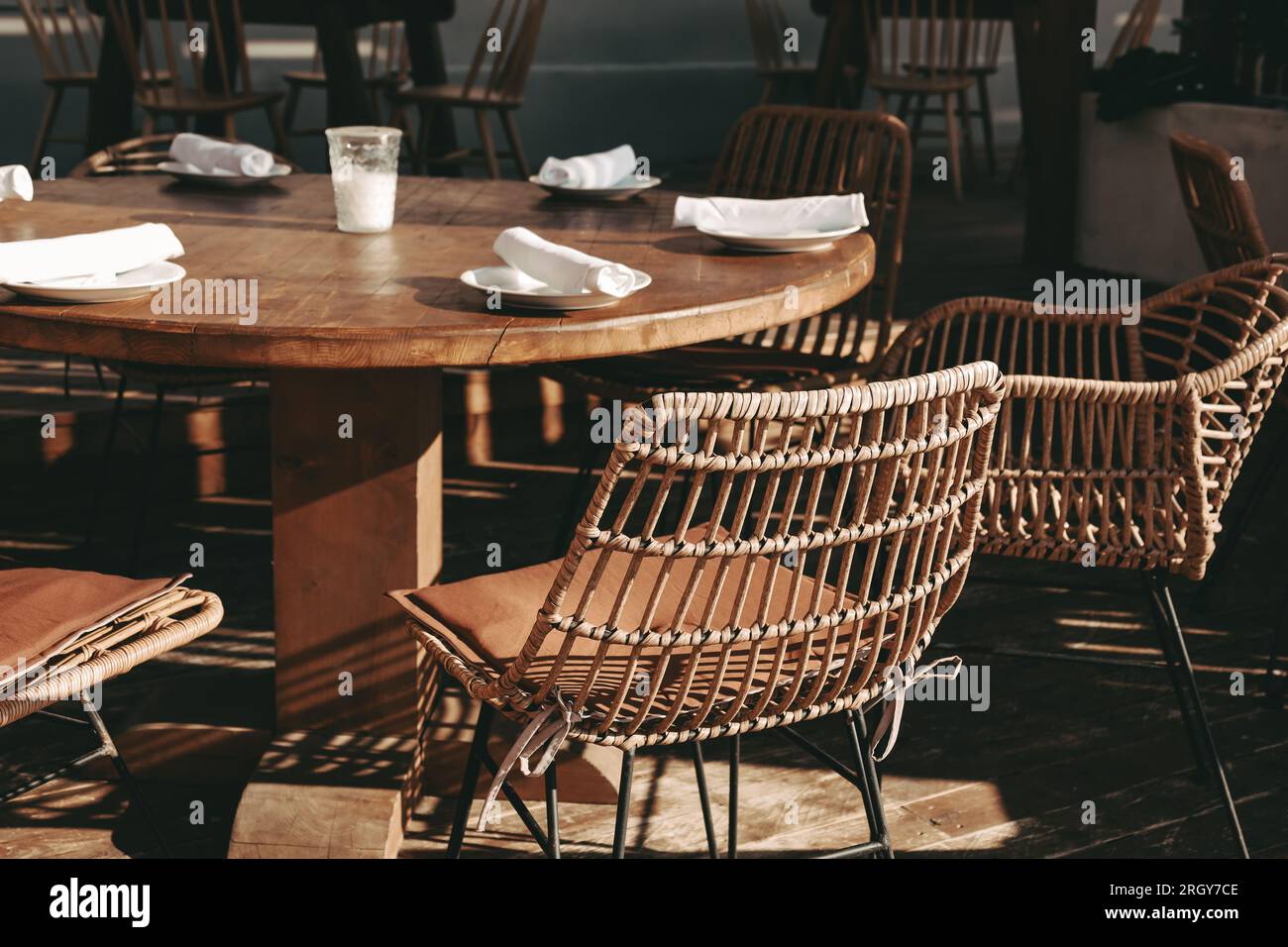 Outdoor empty coffee and restaurant terrace with wooden tables, wicker ...