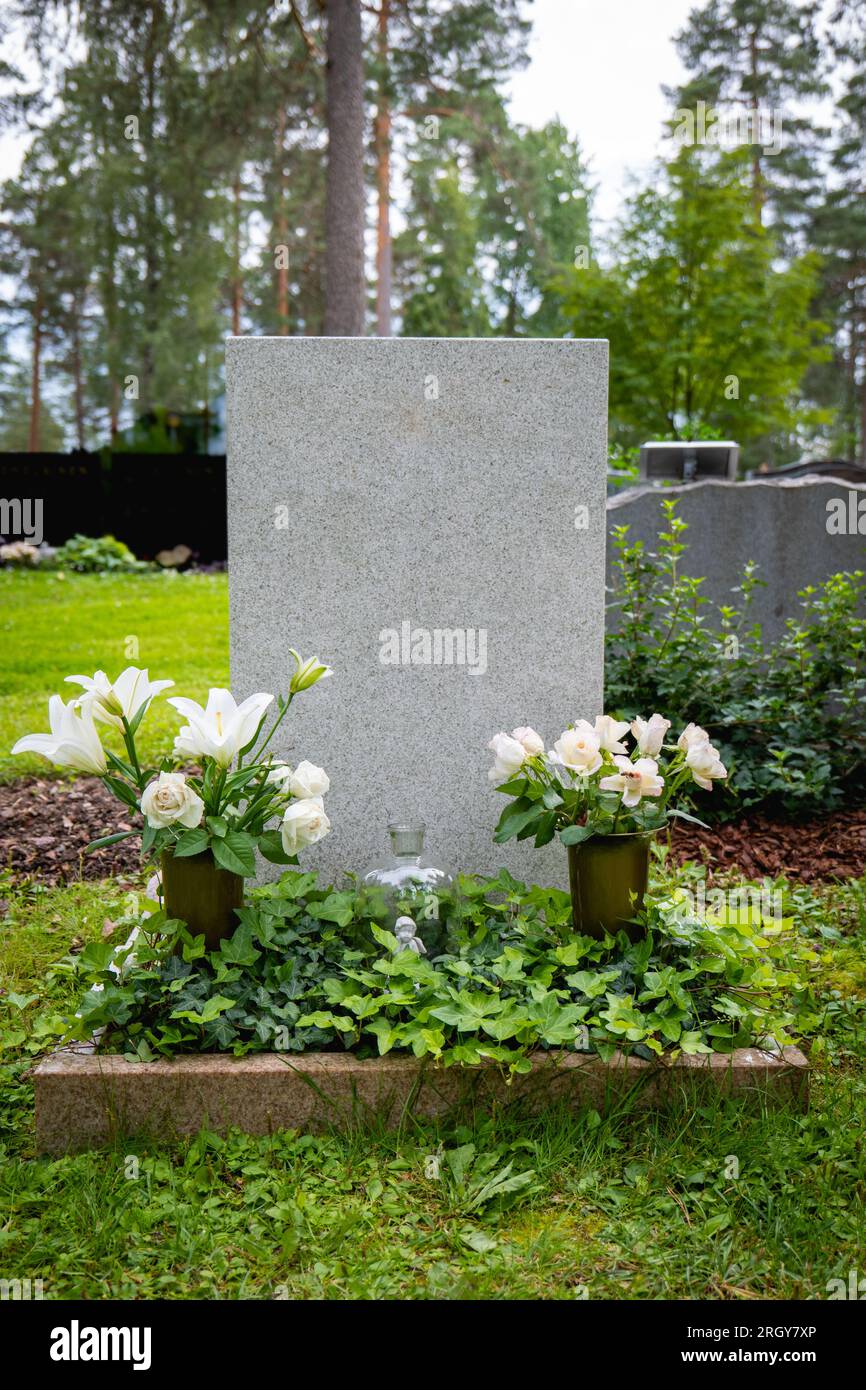 blank gravestone with other graves at graveyard. trees on background ...