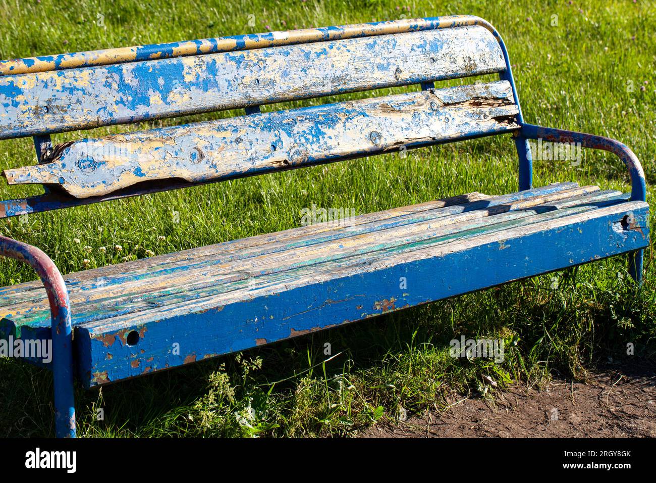 an old bench with stripped paint in the park, an old not repaired bench ...