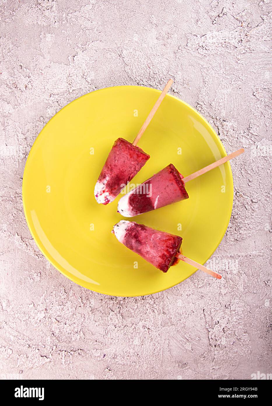 Strawberry ice cream popsicle lolly pops with whipped cream over on ...