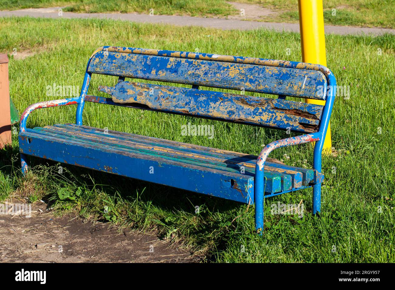an old bench with stripped paint in the park, an old not repaired bench ...