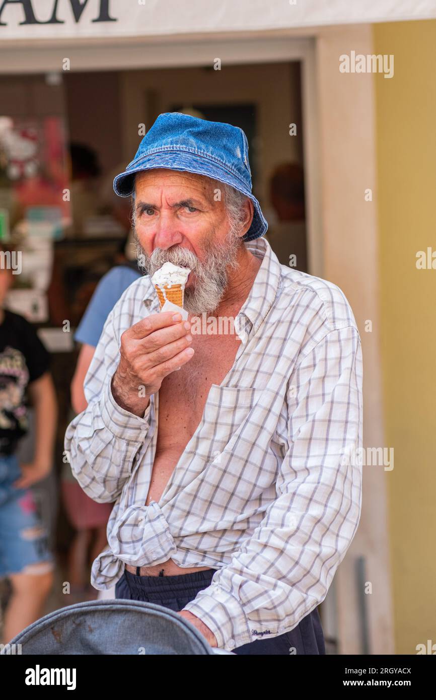 Handsome aged man with ice cream in hand. Old man with a beard in ...