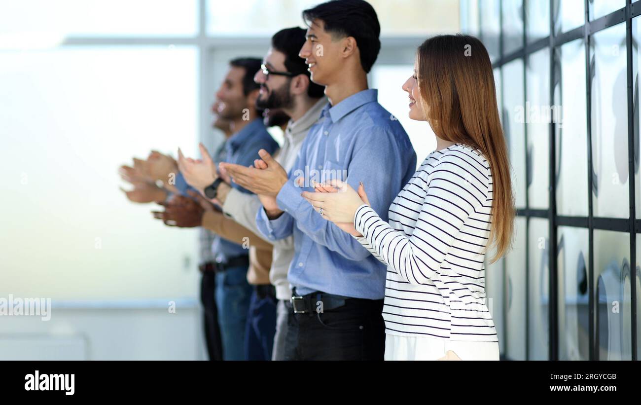 A group of people standing in a row clapping their hands Stock Photo ...