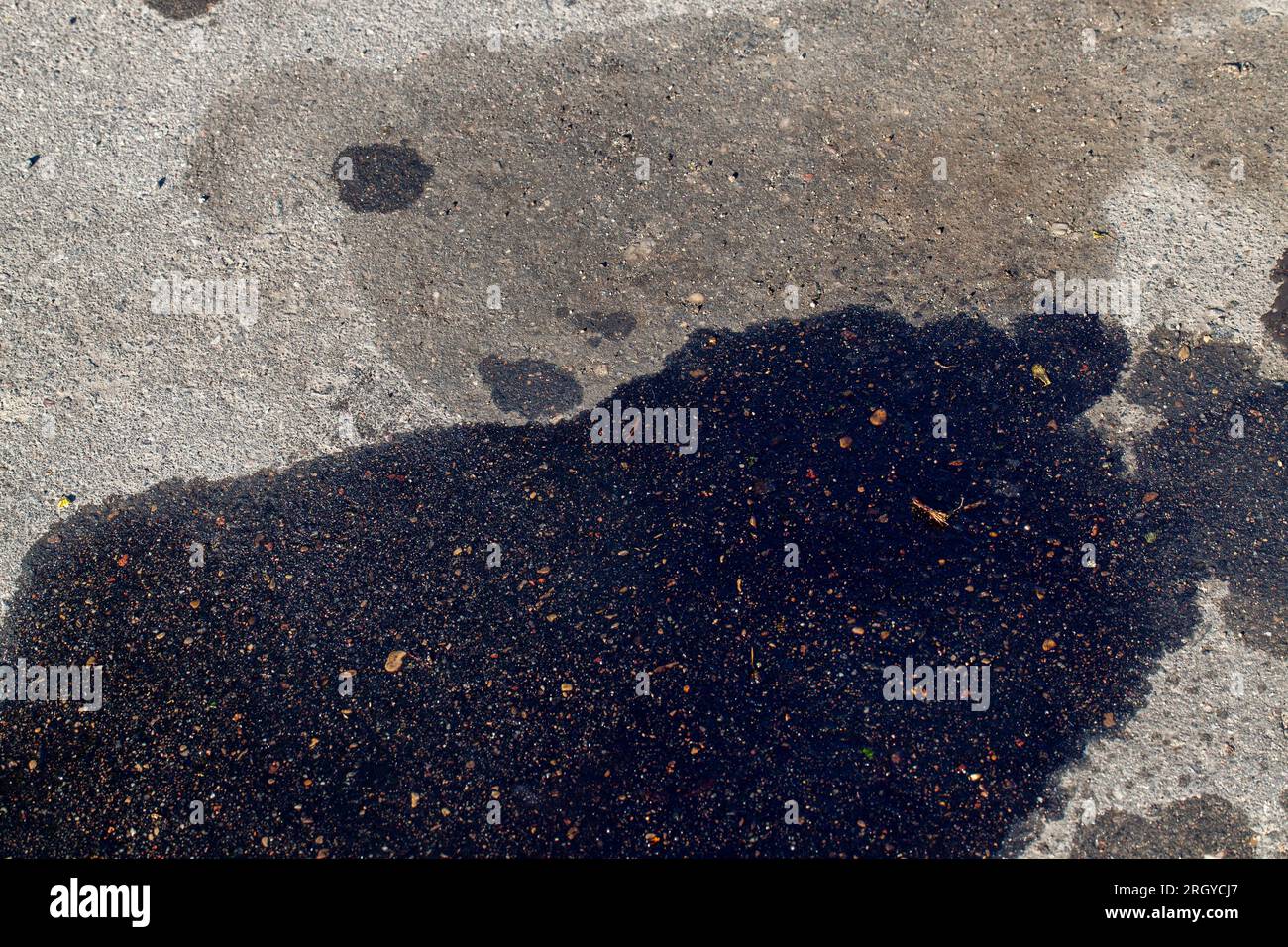 a large number of car oil stains on an asphalt road, environmental ...