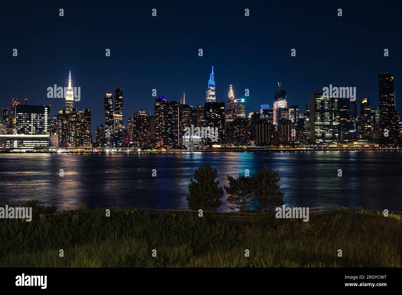 Iconic Manhattan skyline seen from Long Island City. Trees in the ...