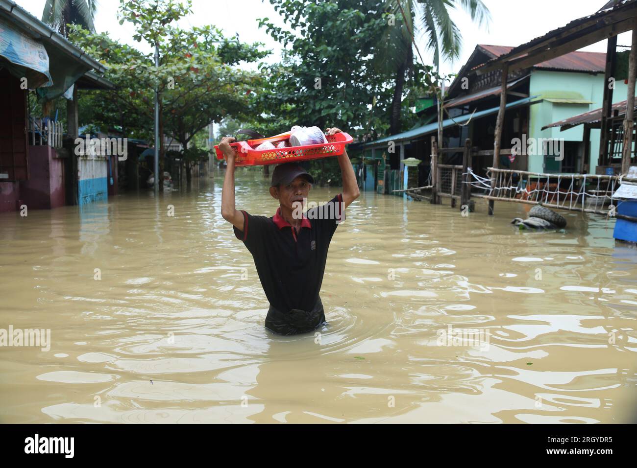 Bago, Myanmar. 12th Aug, 2023. A man wades through flood water in Bago ...