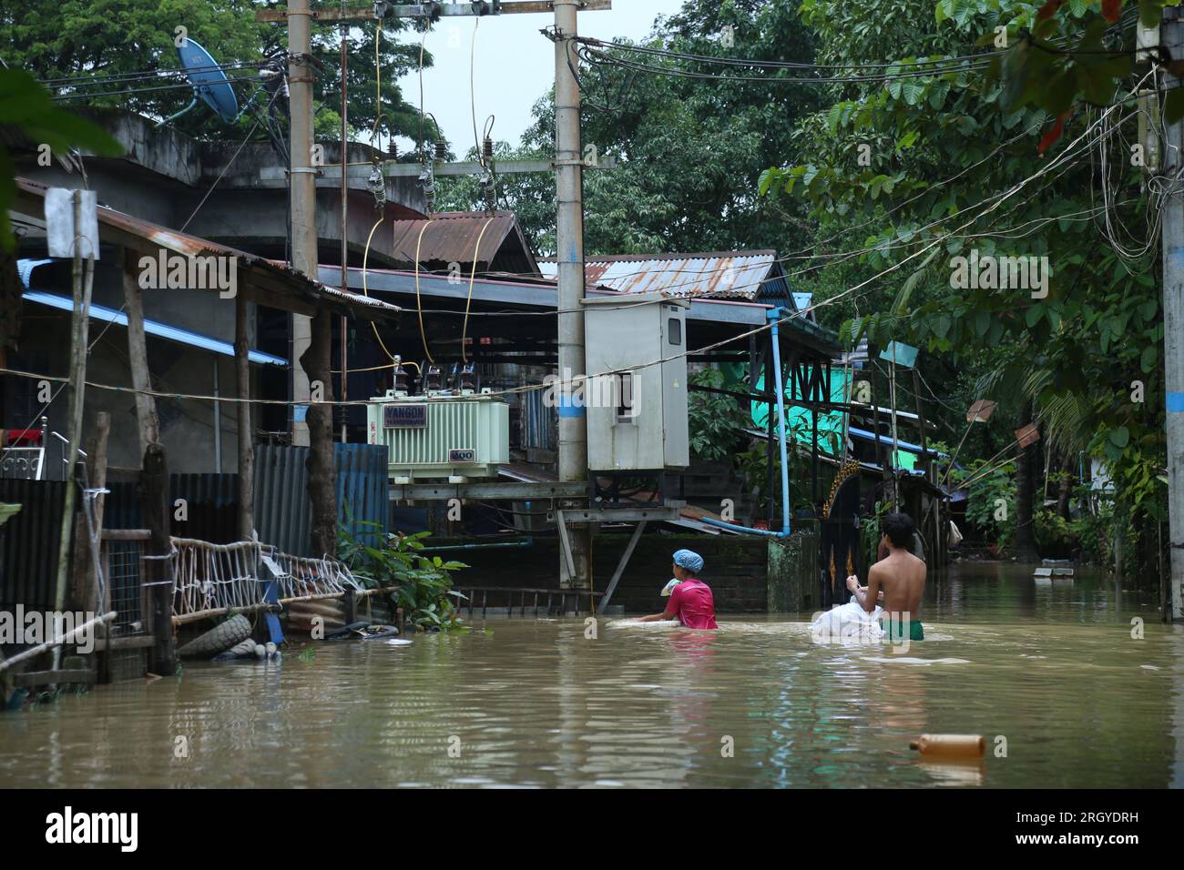 Bago, Myanmar. 12th Aug, 2023. People wade through flood water in Bago ...