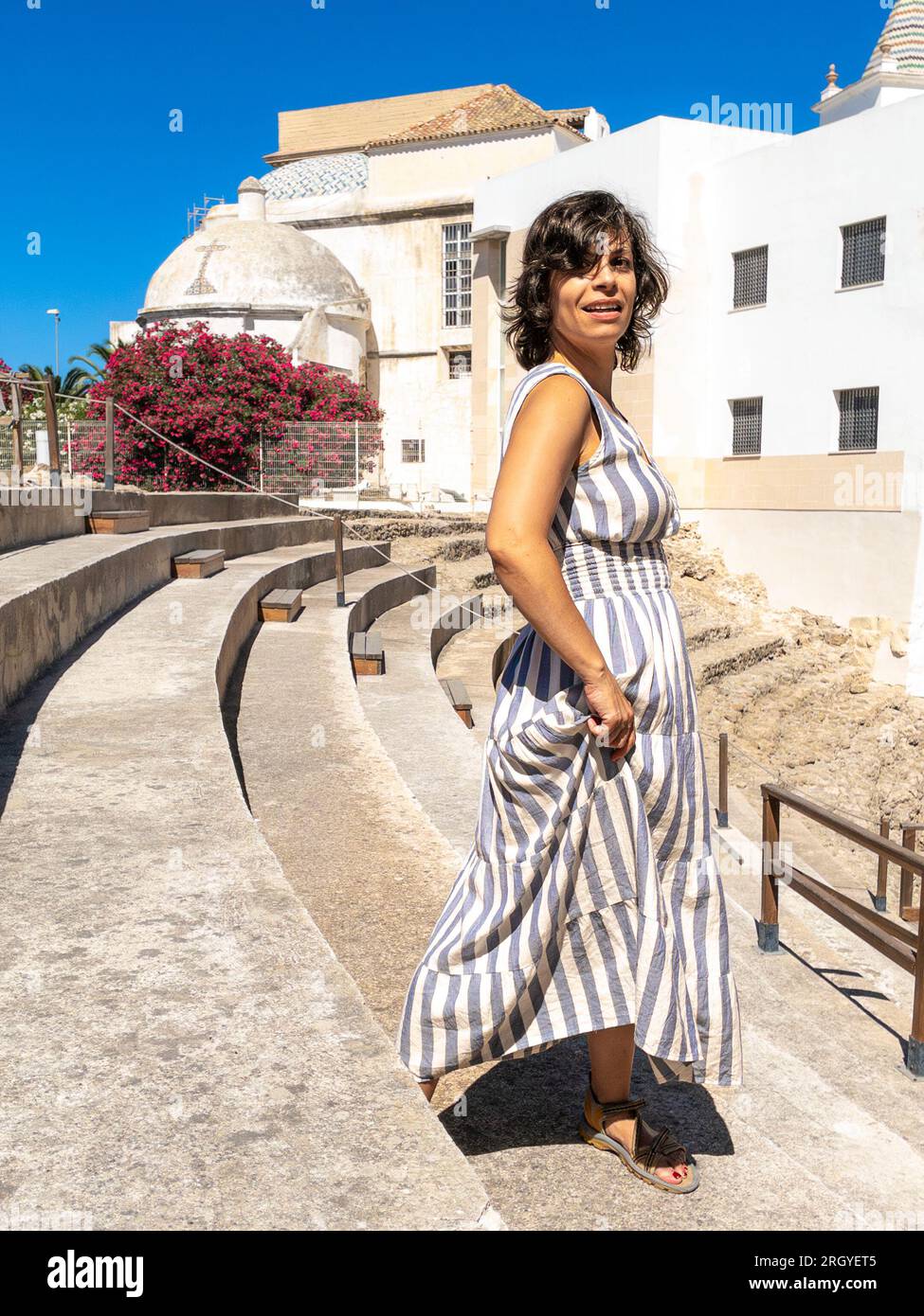 Caucasian tourist showcasing a summer dress and a vintage straw hat ...