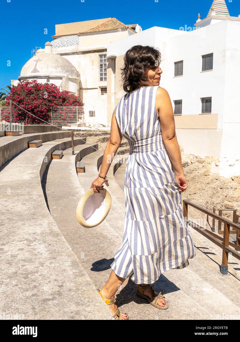 Caucasian tourist showcasing a summer dress and a vintage straw hat ...