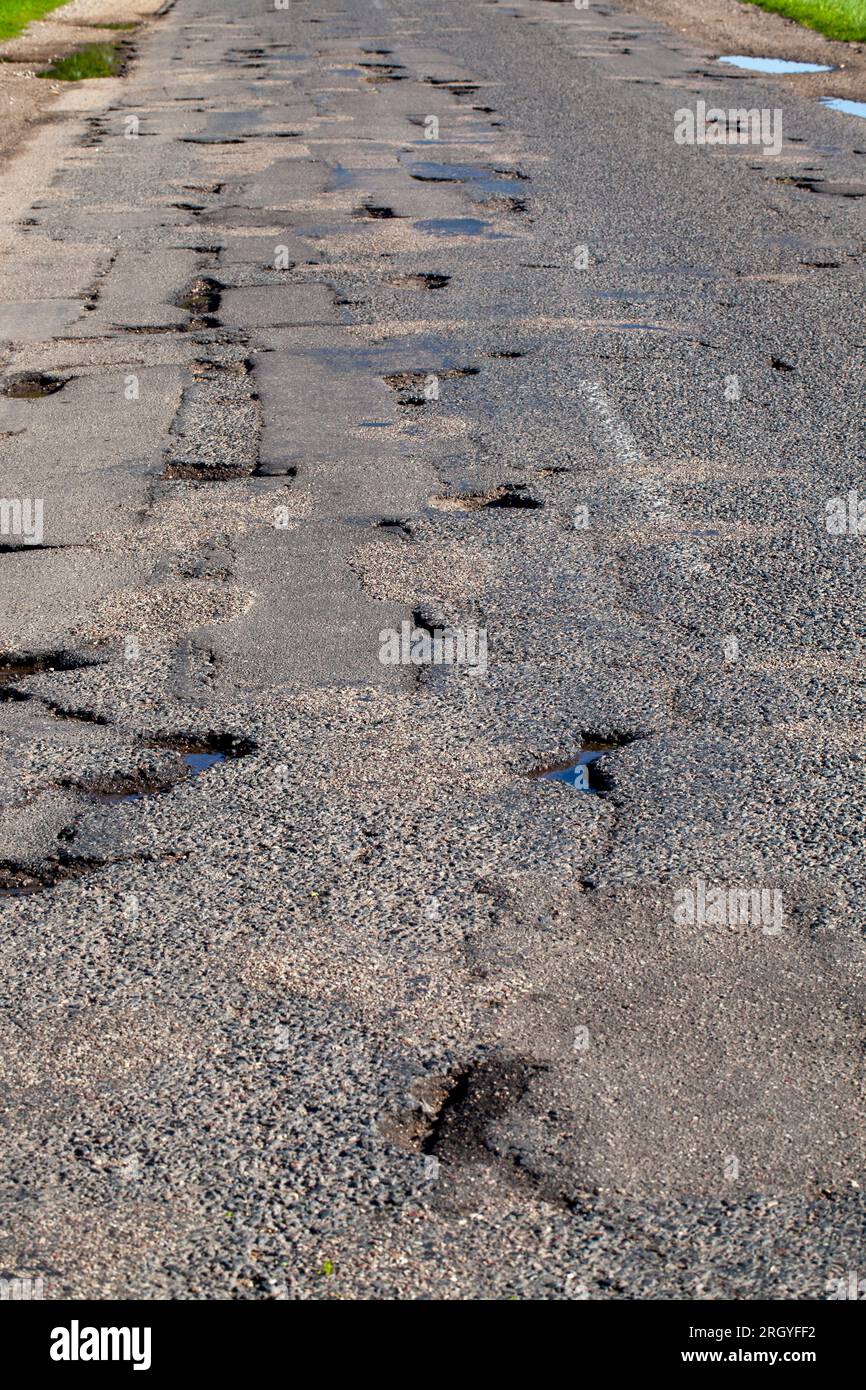 details of an asphalt road with cracks and holes, part of the ...