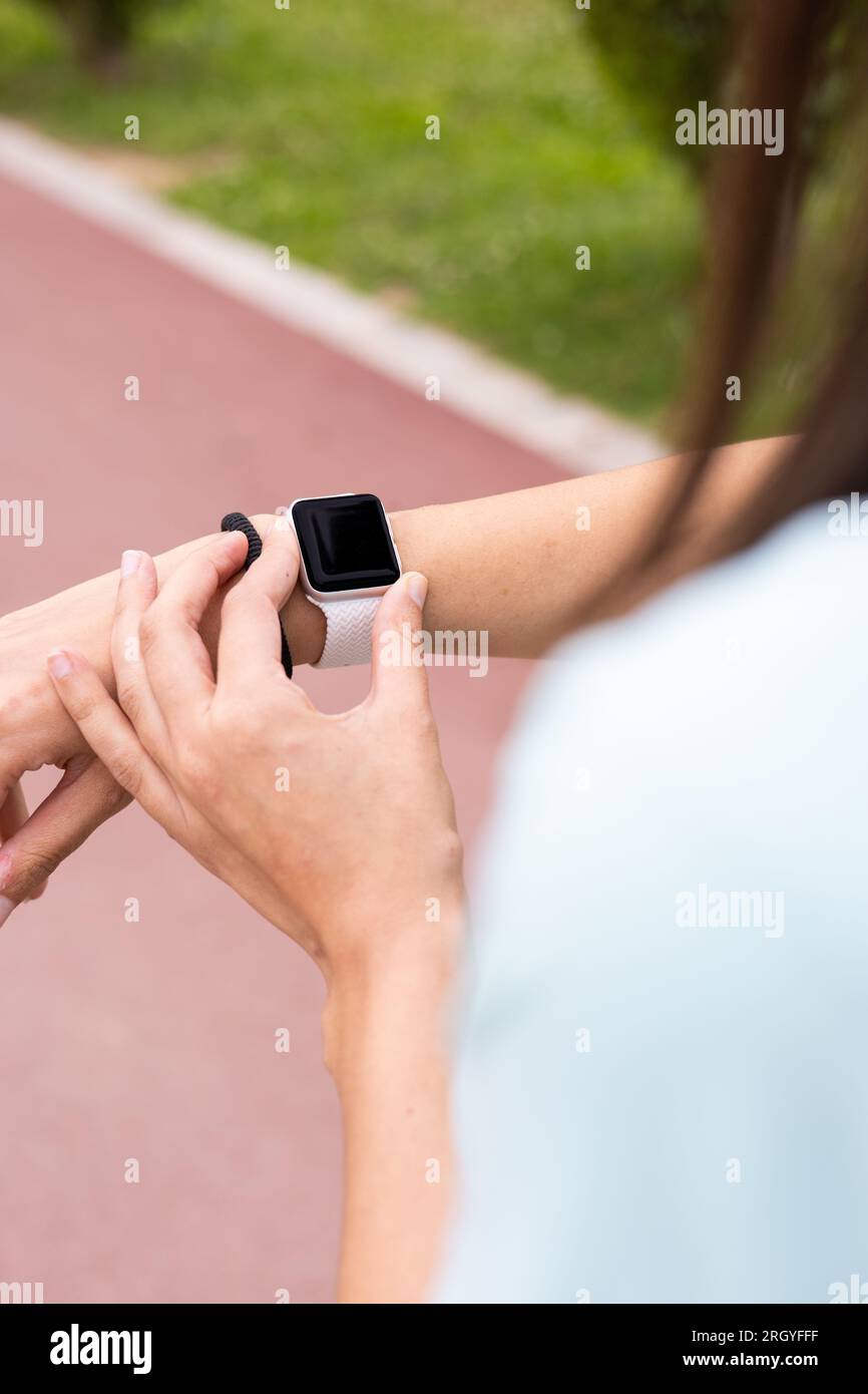 Female athlete checking a smartwatch tracker for running outdoors ...