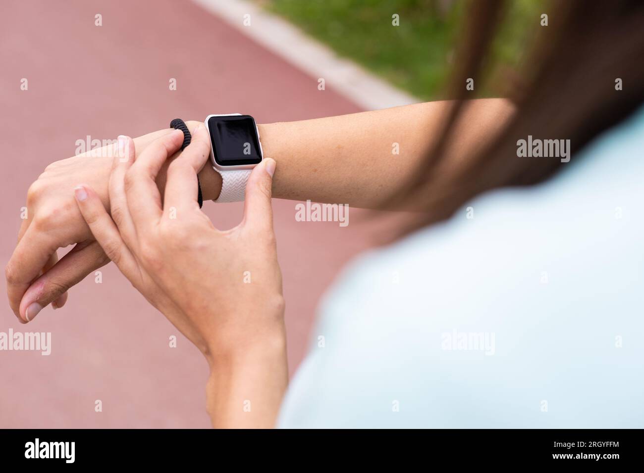 Female athlete checking a smartwatch tracker for running outdoors ...
