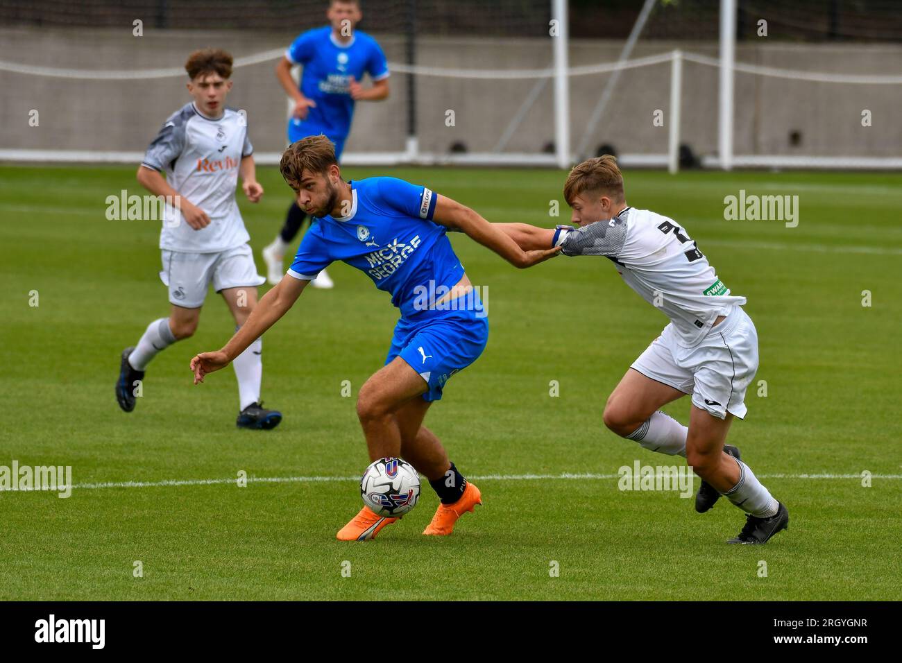 Swansea, Wales. 12 August 2023. Tyler Winters of Peterborough United holds off the challenge ...