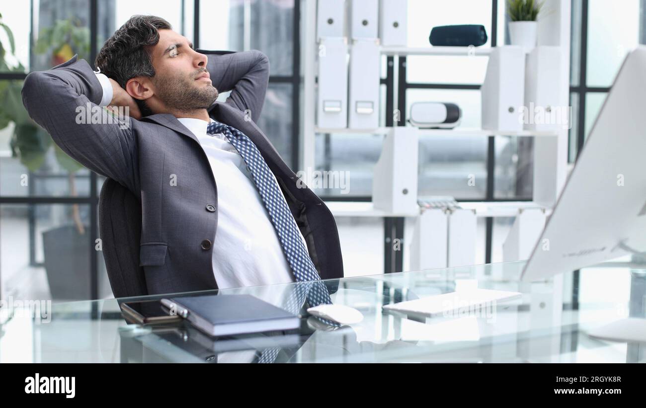 Taking time for a minute break. Cheerful young man holding hands behind ...