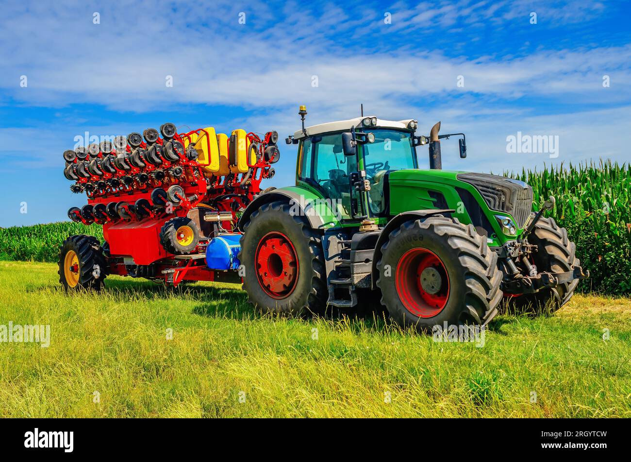 Agricultural machinery sideways near corn field. Big tractor. White ...
