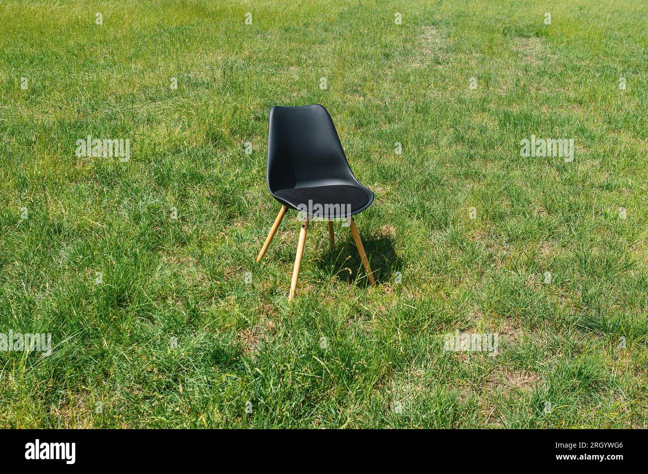 Black chair on field of green grass in summer. Front view. Outdoor ...