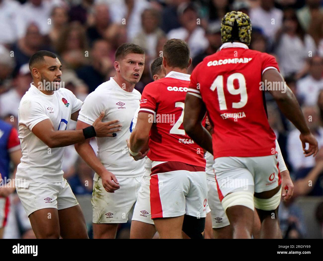 England's Owen Farrell is held back from Wales' Dan Biggar during the Summer Nations Series ...