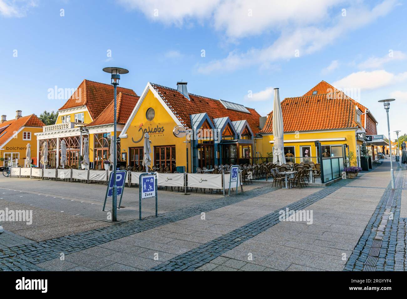 Skagen city street with traditional yellow houses and restaurants ...