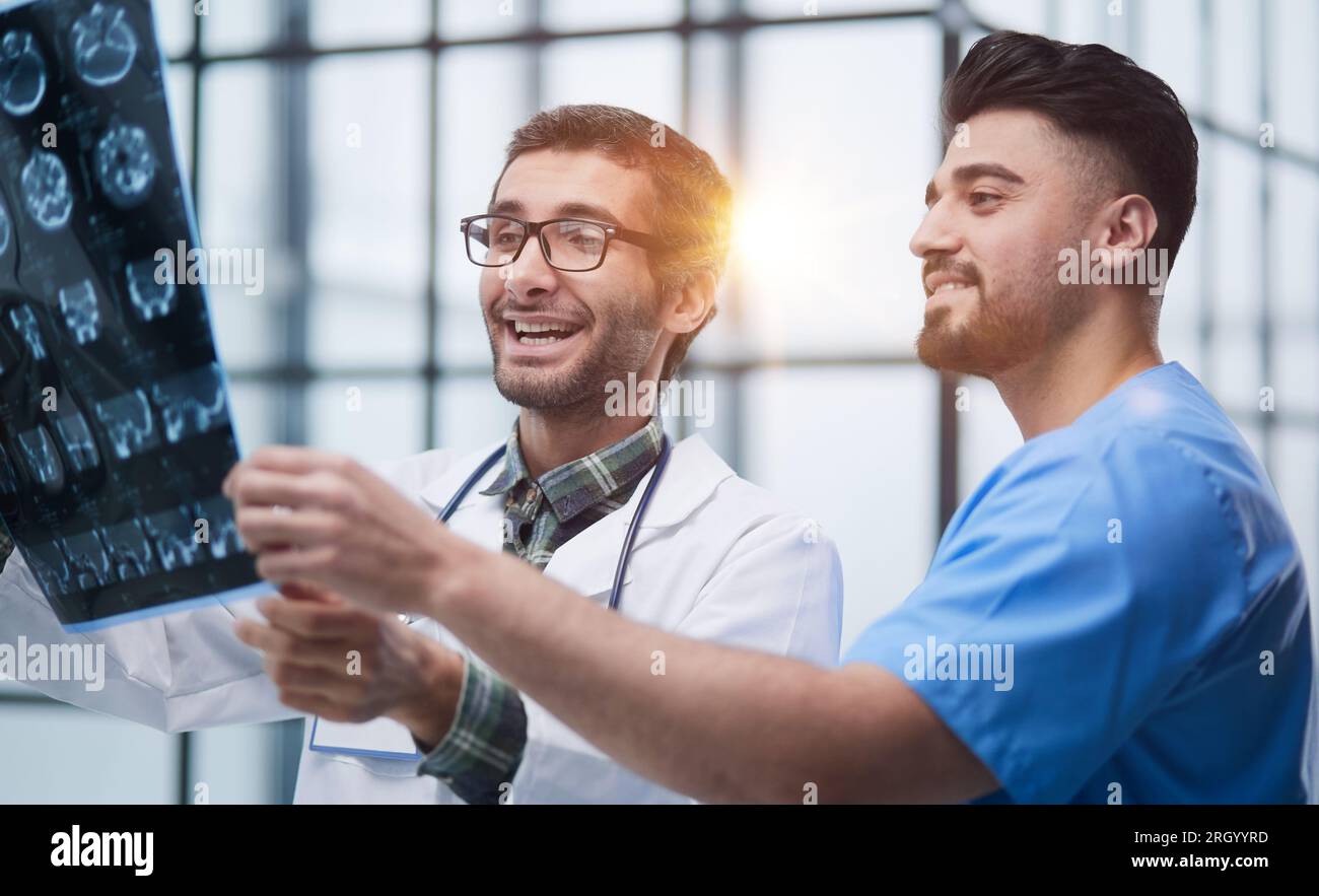 two professional radiographers hold and examine a radiograph for ...