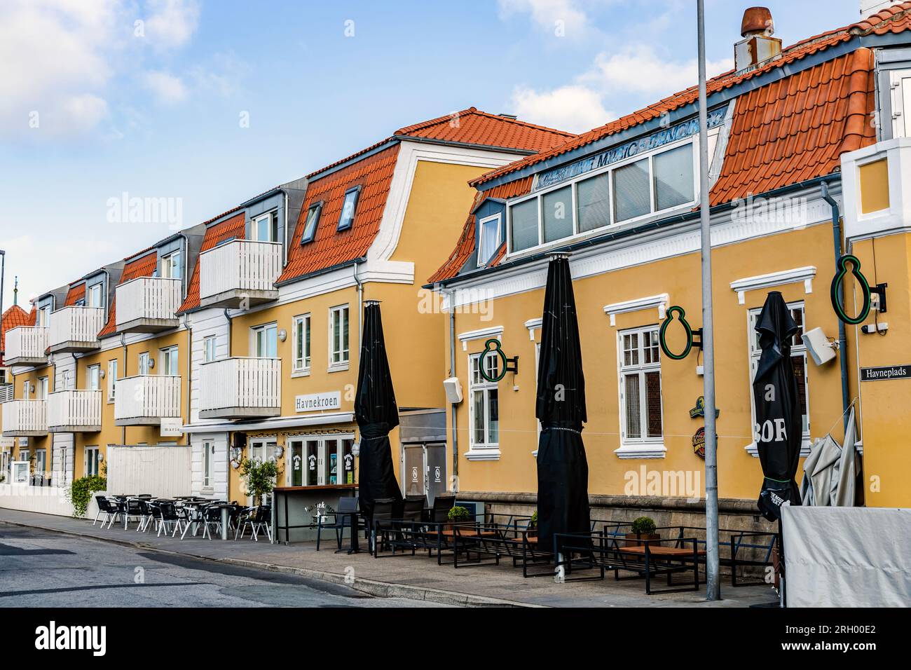 Skagen city street with traditional yellow houses and restaurants ...
