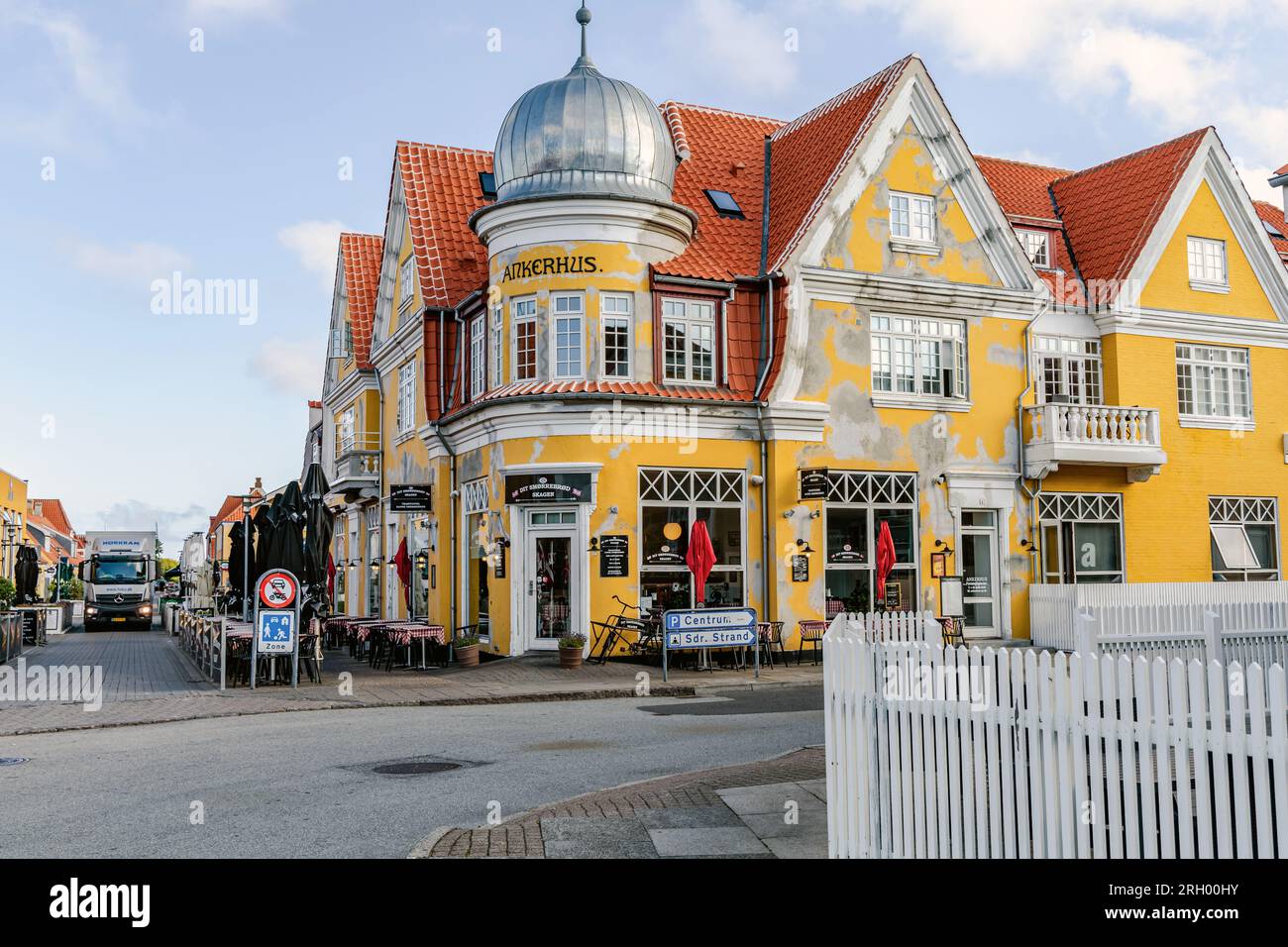 Skagen city street with traditional yellow houses and restaurants ...