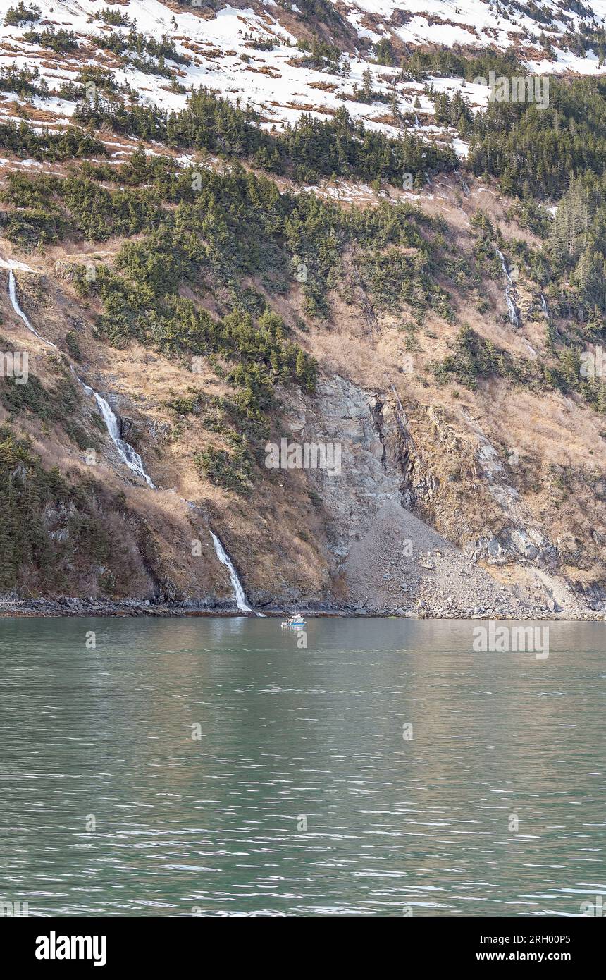 Fishing Boat dwarfed by snow melt water stream on the side of a ...