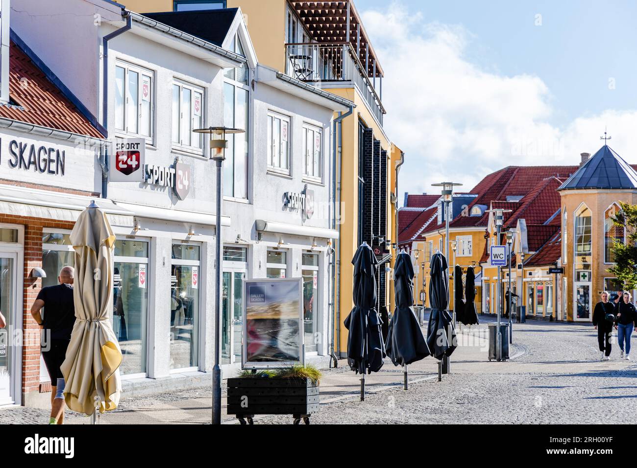Skagen city street with traditional yellow houses and restaurants ...