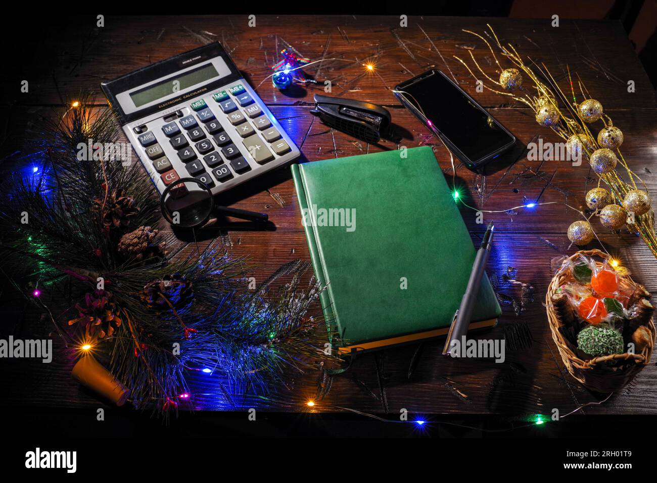 Work diary on the table. Festive mood. Christmas garlands and ...