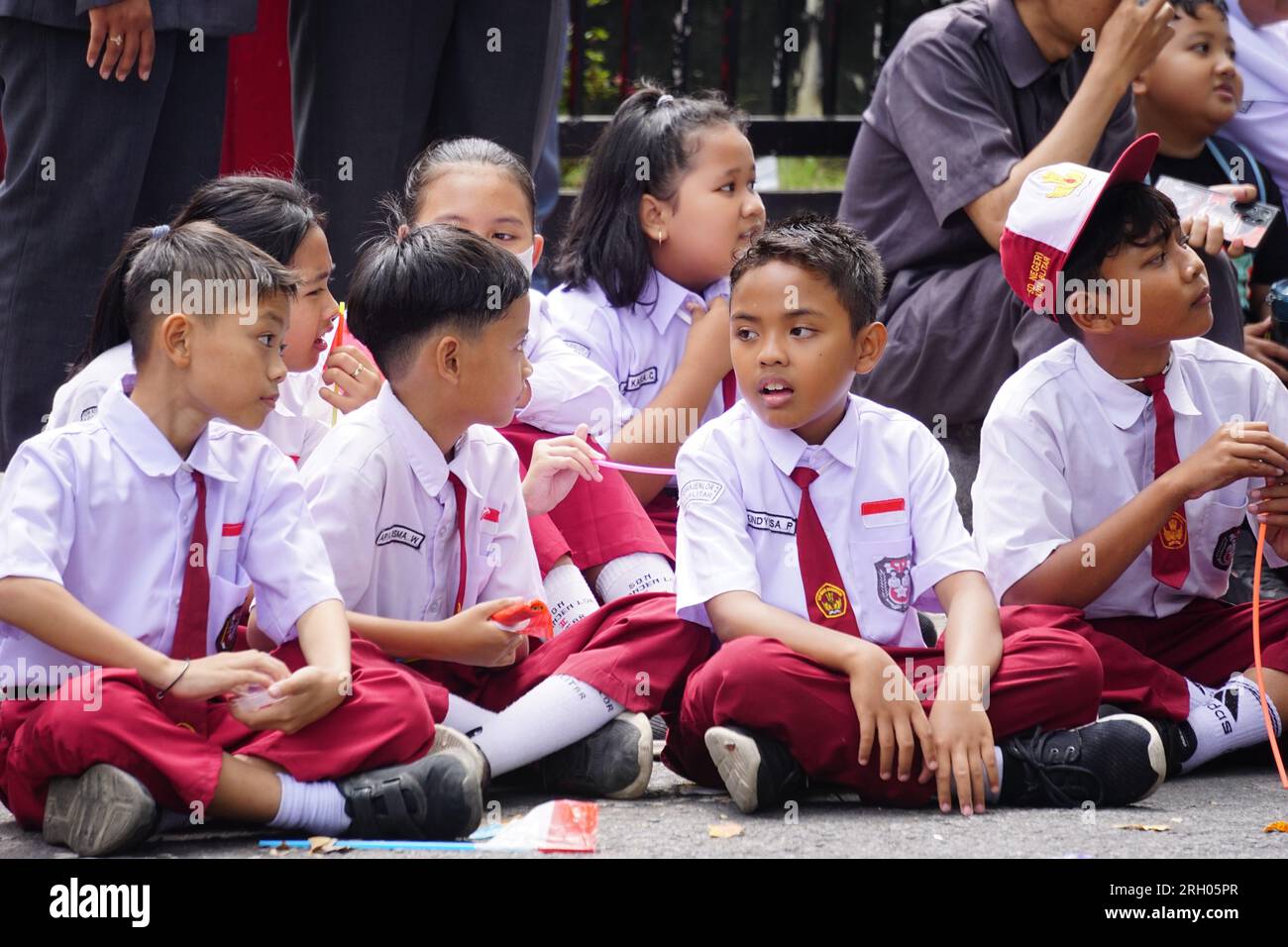 Indonesian elementary school students with their friends holding red ...