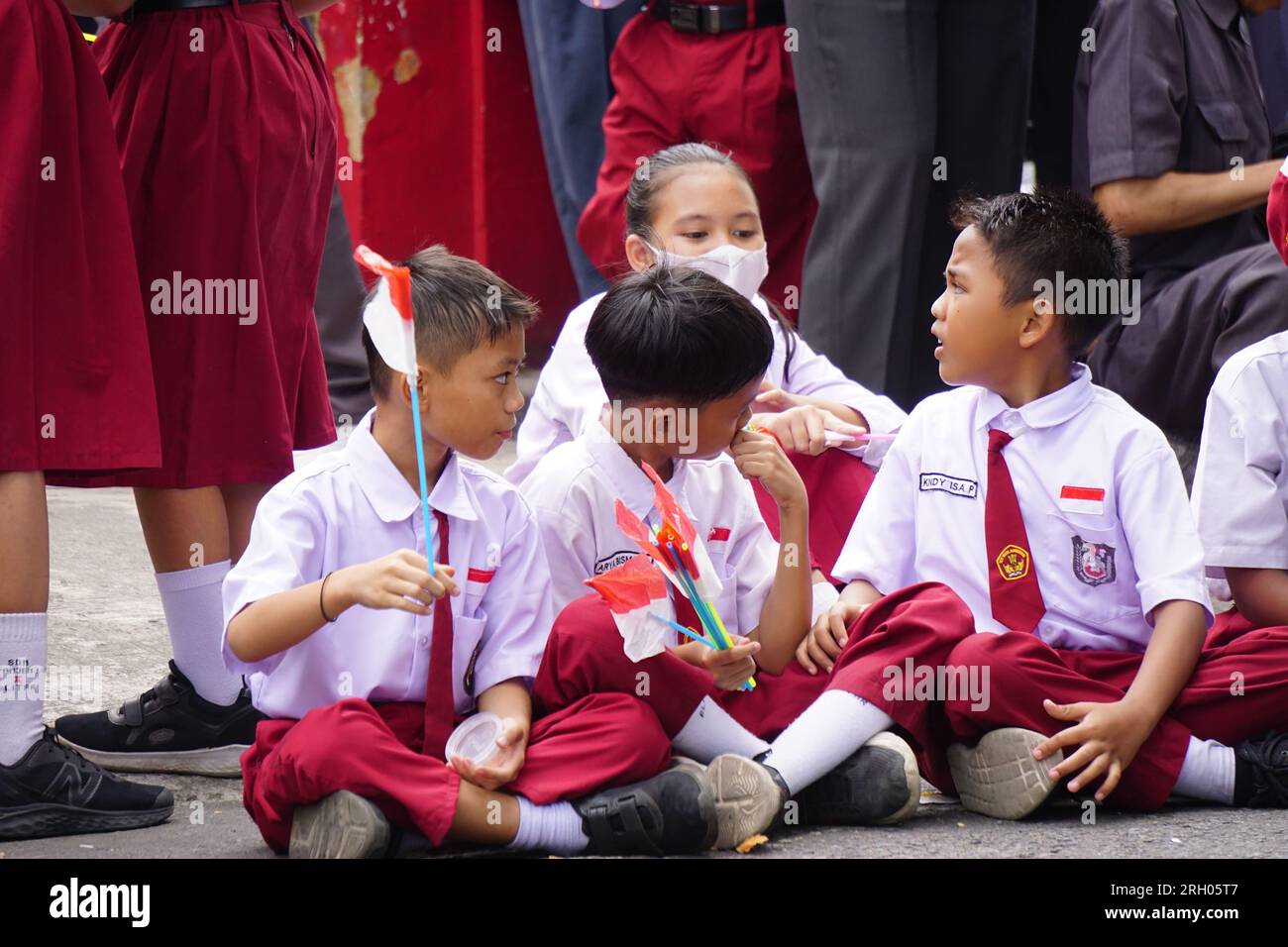 Indonesian elementary school students with their friends holding red ...