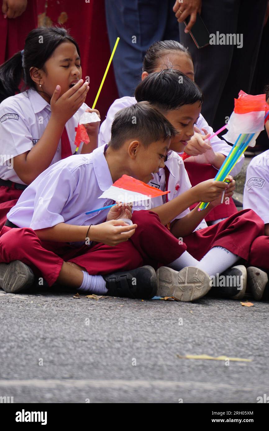 Indonesian elementary school students with their friends holding red ...