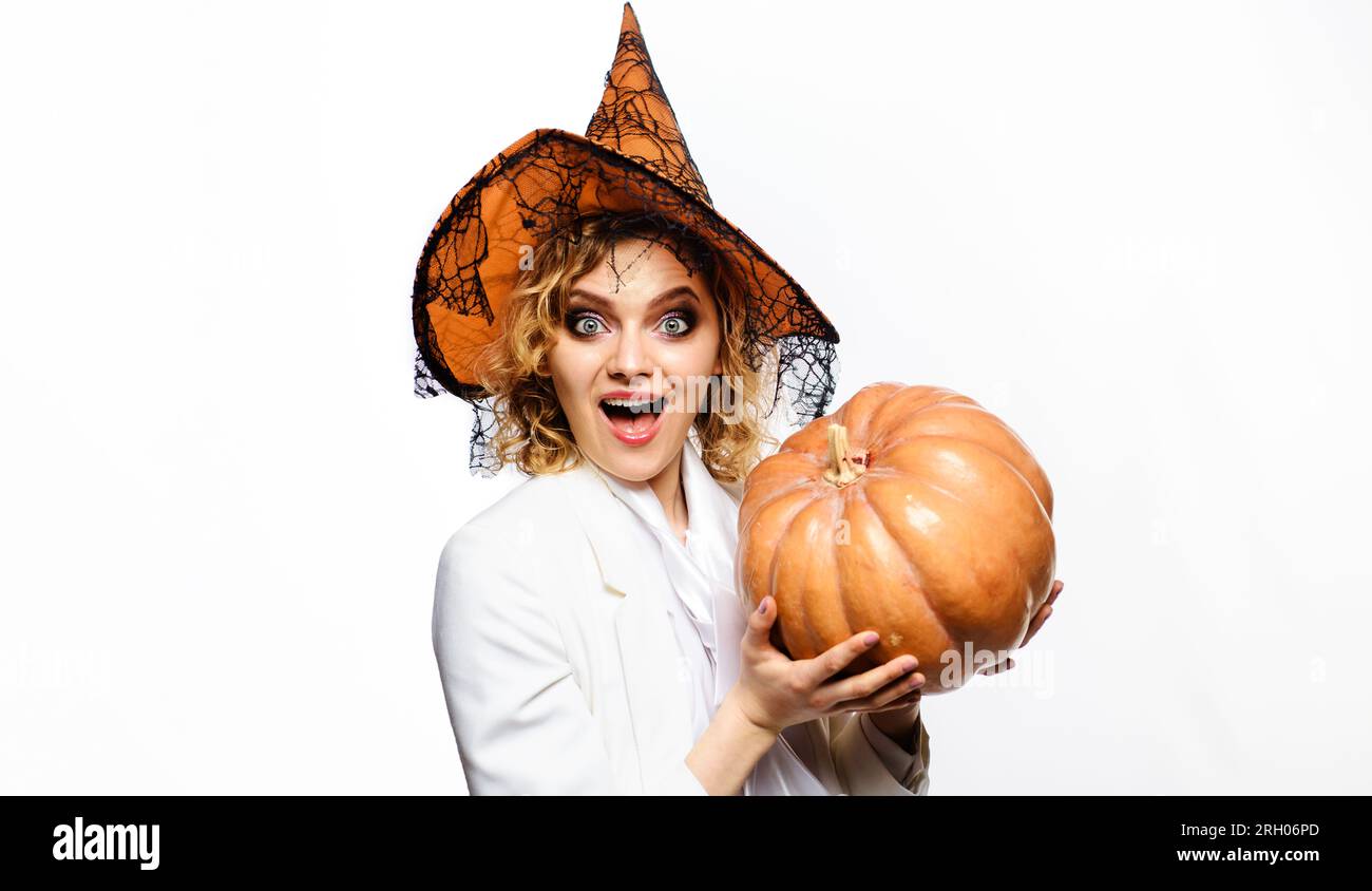 Surprised Halloween witch with pumpkin. Pretty female model with ...