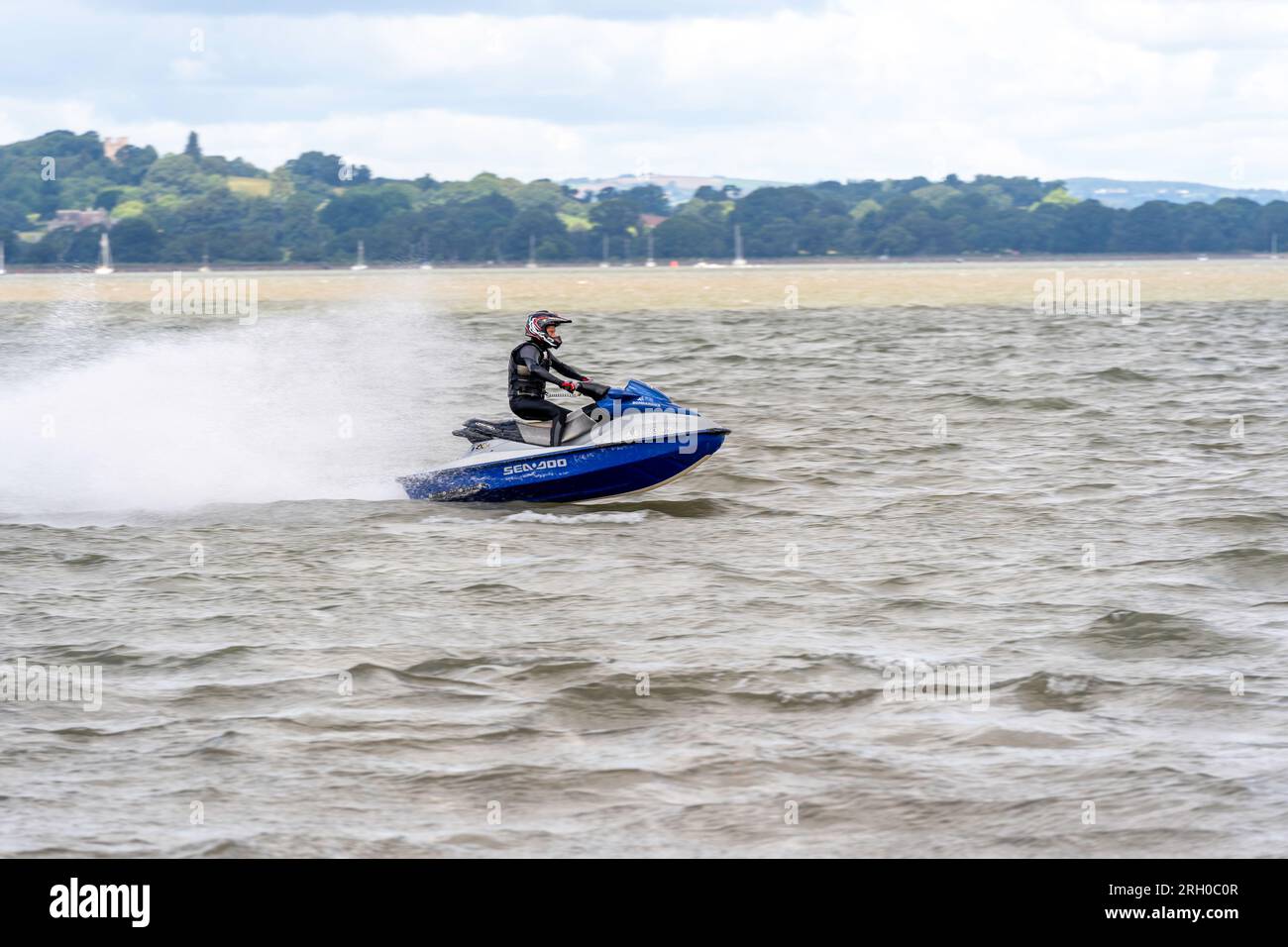 Exmouth, UK - August 2023:A young man drives a jet ski in the river Exe ...