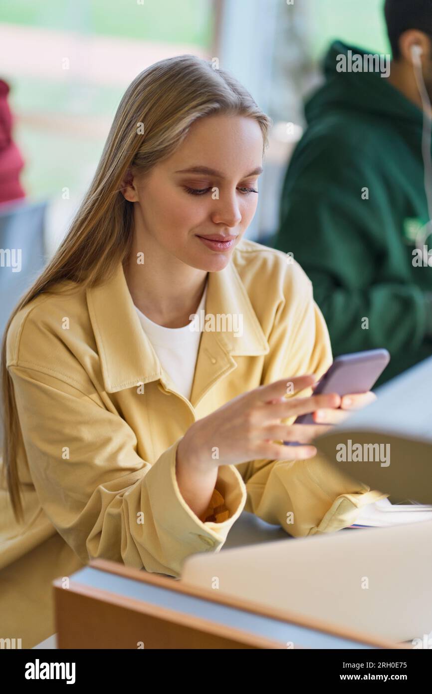 Teen girl gen z student using cell phone looking at smartphone ...