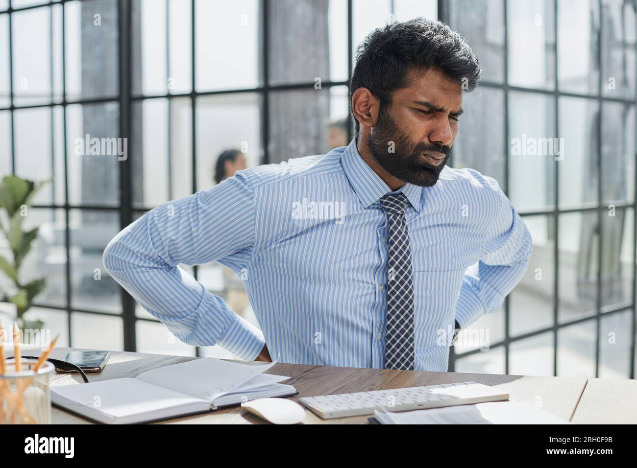 Business man with back pain an office. Pain relief concept Stock Photo ...