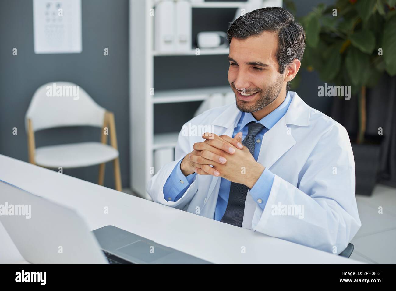 doctor waving hand to patient via laptop video link Stock Photo - Alamy